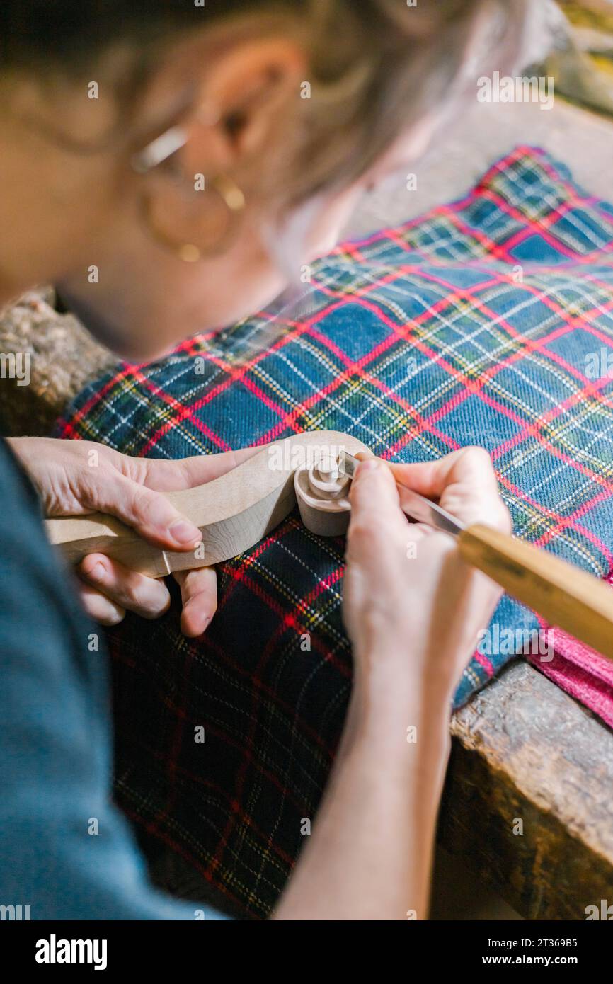 Luthier carving violin scroll in workshop Stock Photo - Alamy