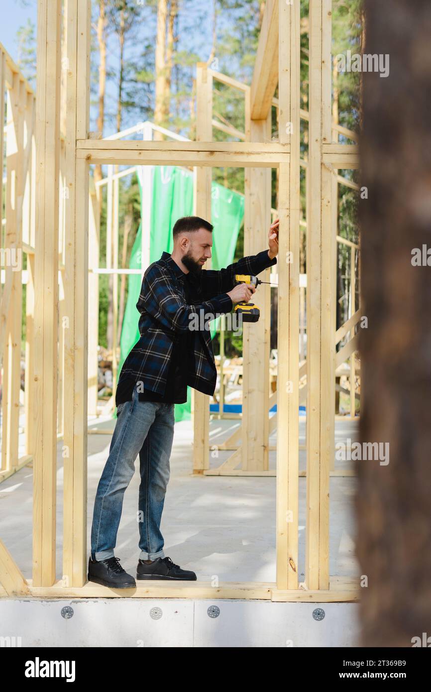 Engineer drilling wood with work tool at site Stock Photo - Alamy