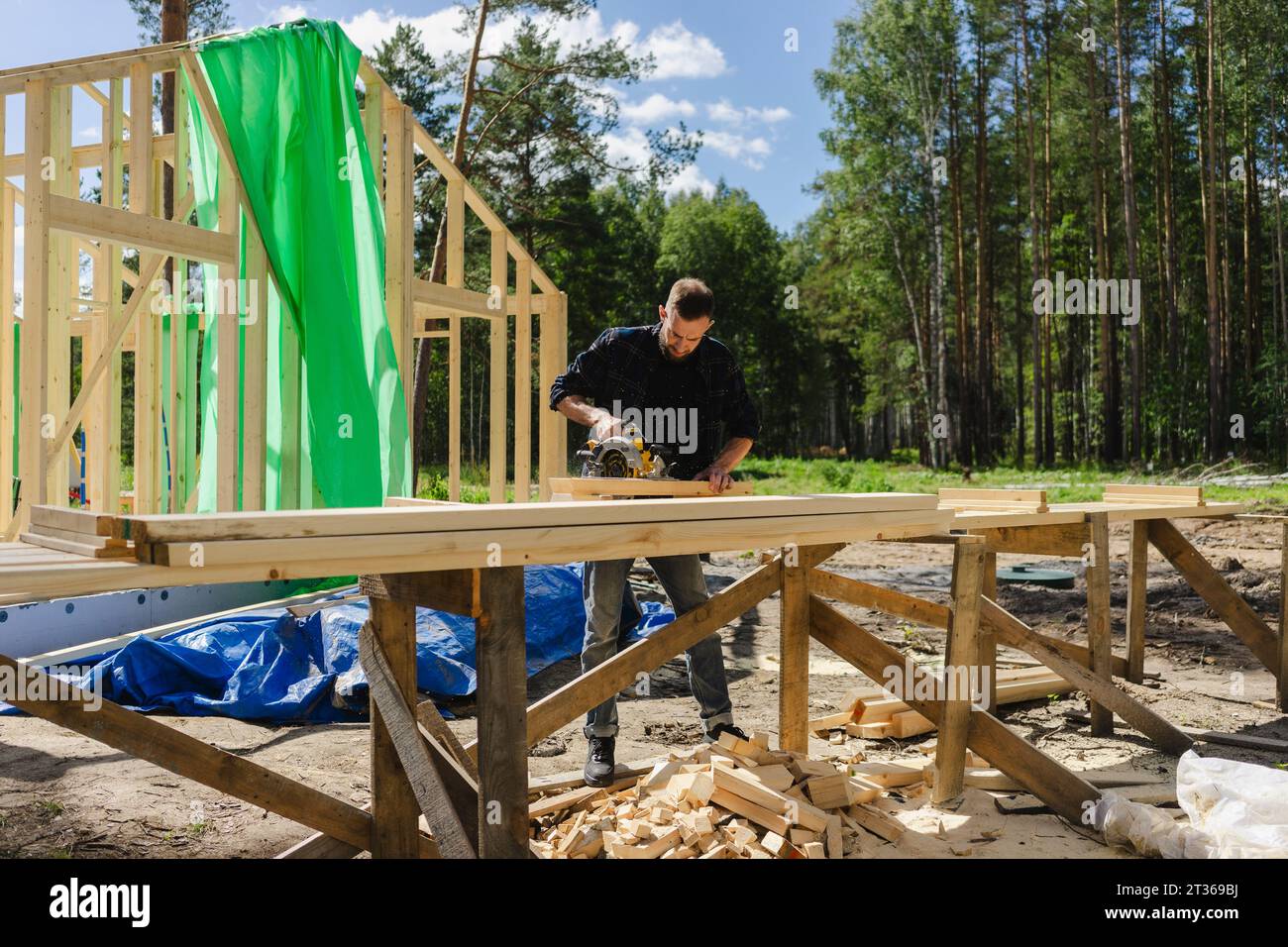Engineer working with machine on plank at construction site Stock Photo ...