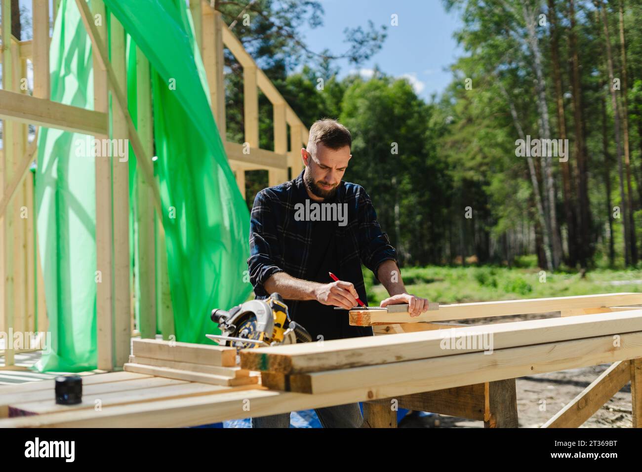 Engineer measuring wood at construction site Stock Photo - Alamy