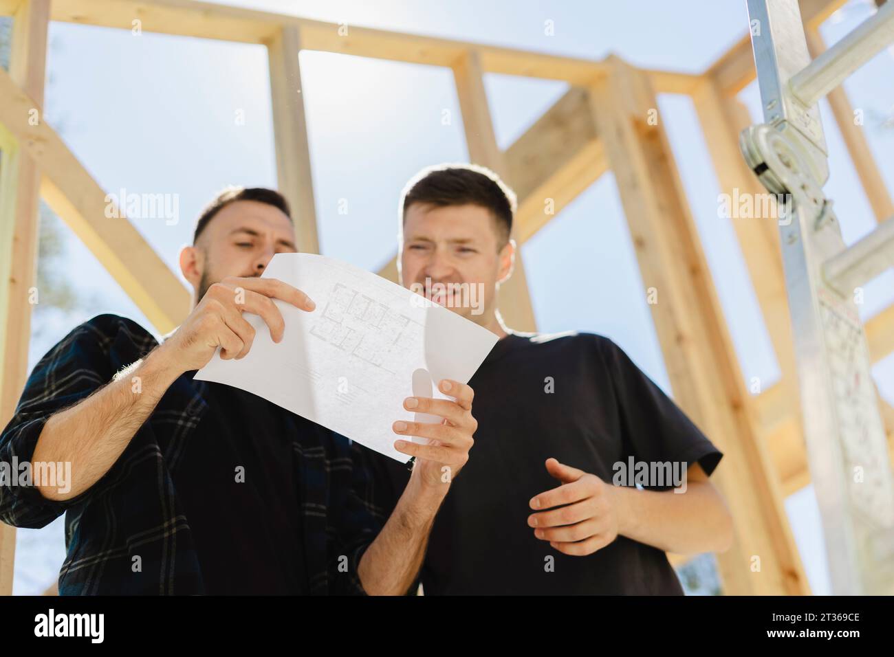 Engineers looking at blueprint and discussing near wooden frame Stock ...