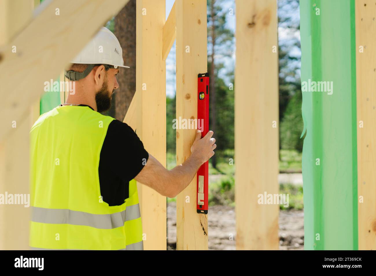 Engineer measuring wood with level tool at site Stock Photo - Alamy
