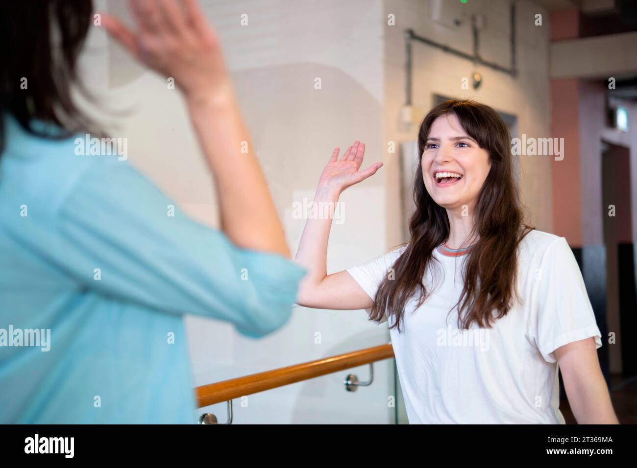 Happy woman giving high-five to friend Stock Photo - Alamy