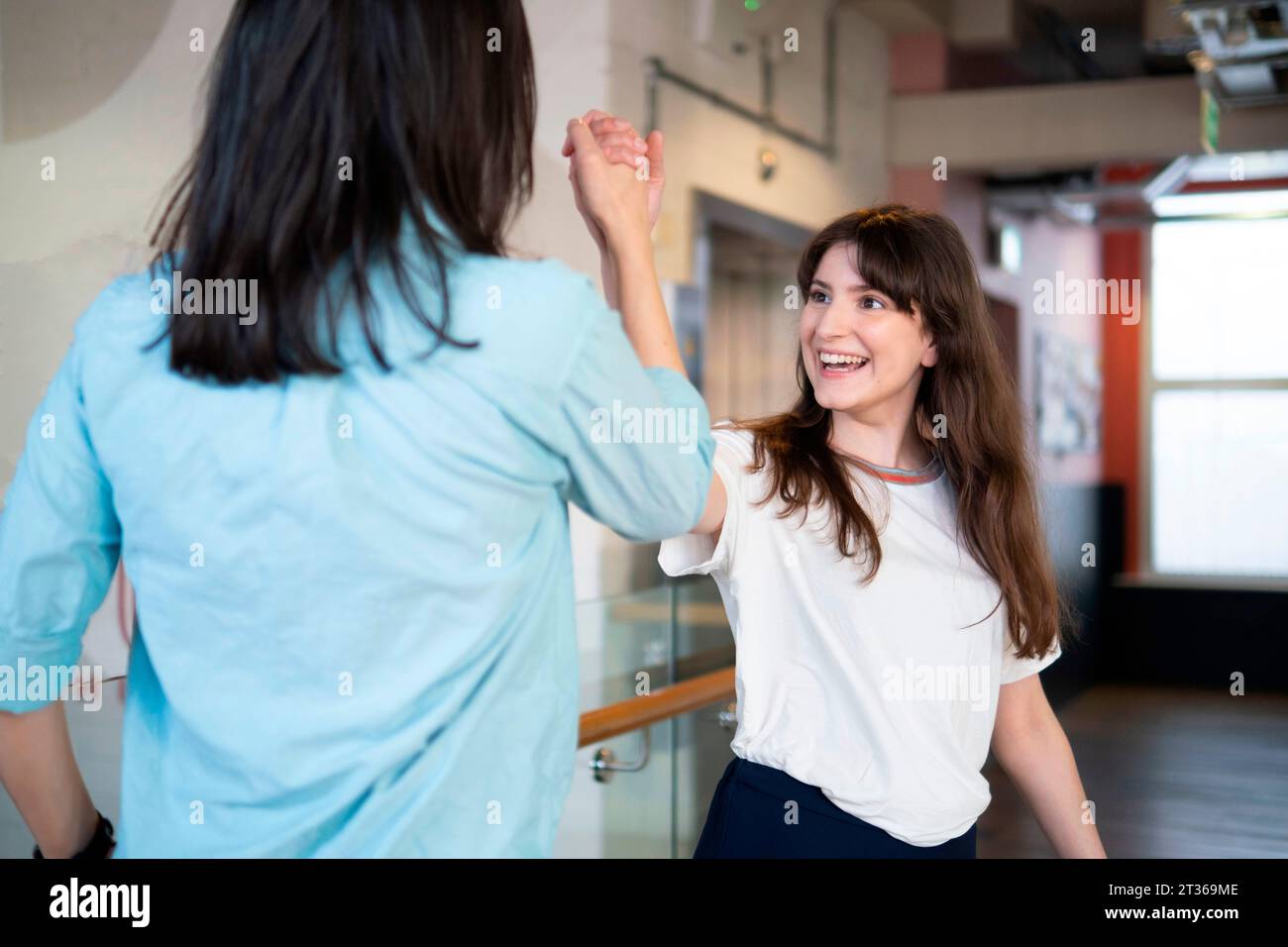 Happy women giving high-five to each other Stock Photo - Alamy