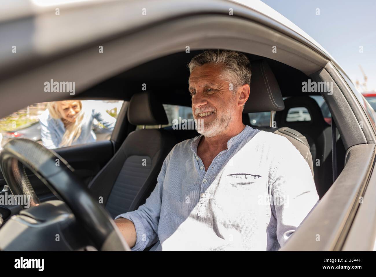 Smiling man sitting on driver's seat of car Stock Photo - Alamy