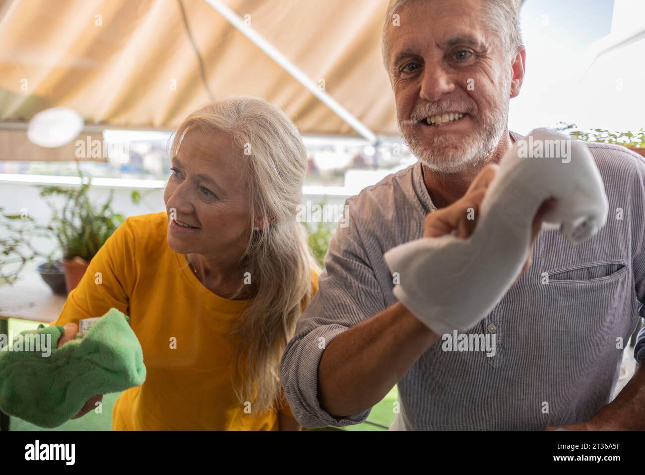 Man cleaning window with rag by woman Stock Photo - Alamy