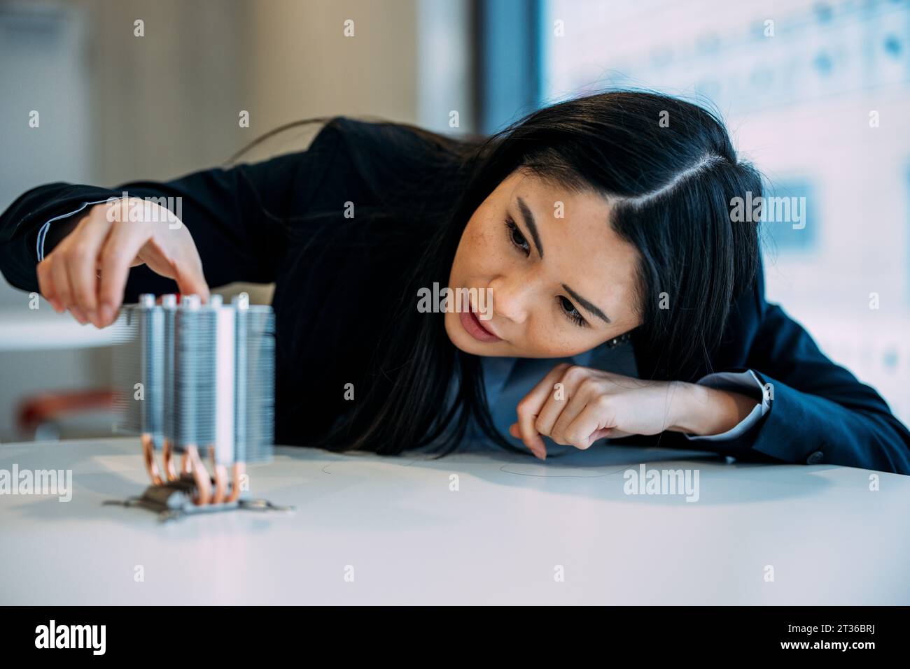 Engineer examining semiconductor at desk in office Stock Photo - Alamy