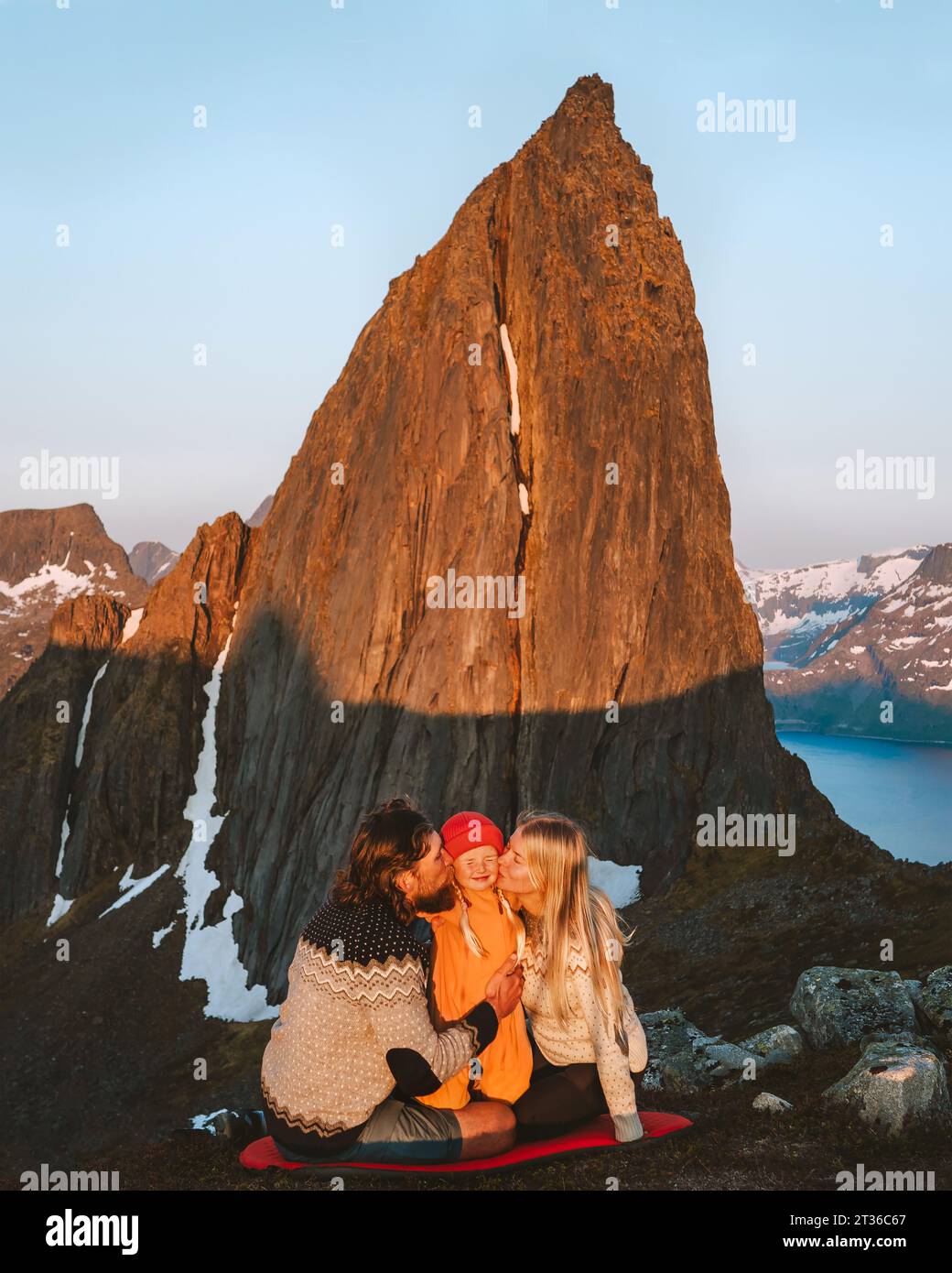 Parents kissing child outdoor camping in mountains travel together in ...
