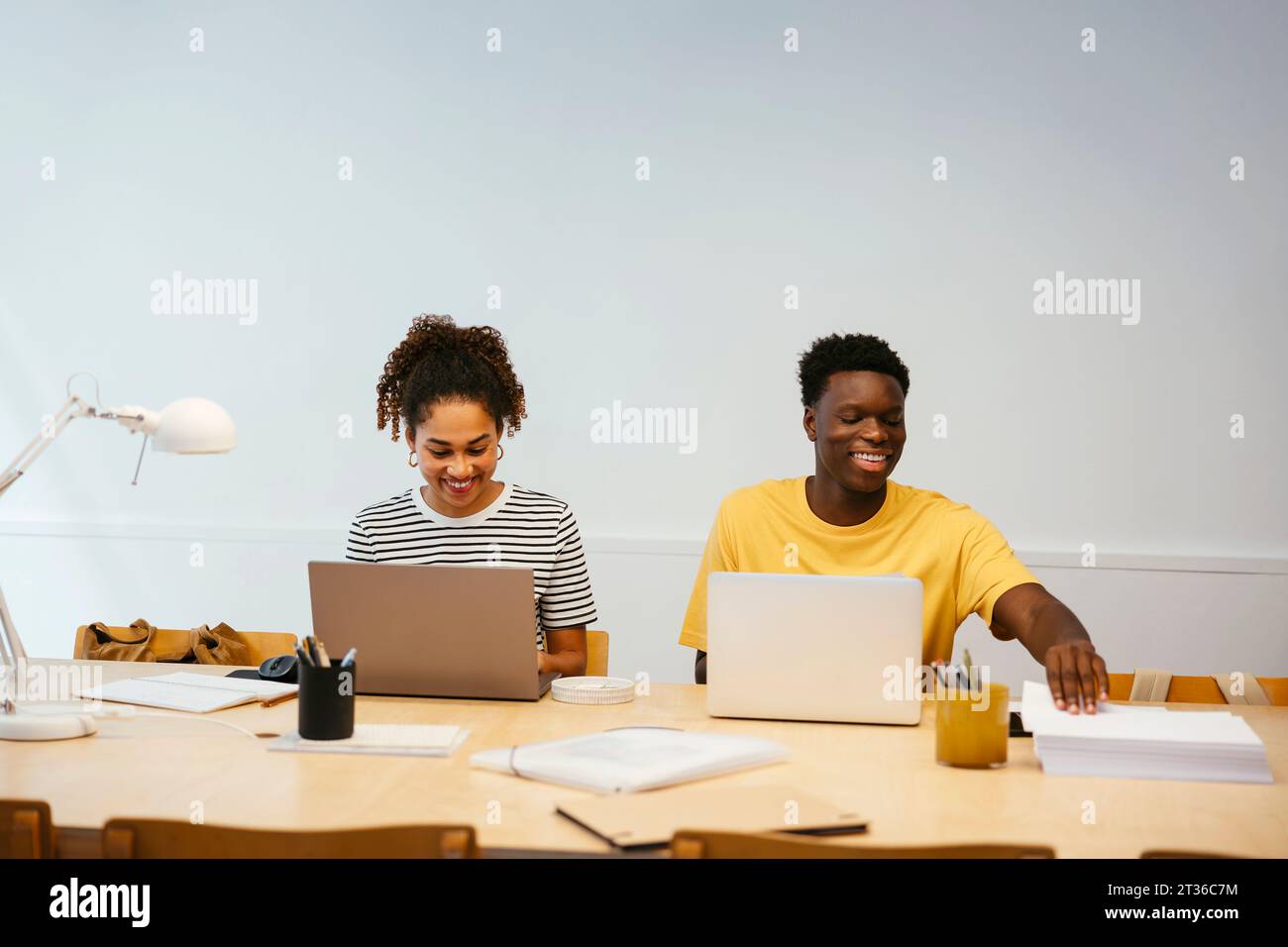 Happy students studying together at university Stock Photo - Alamy