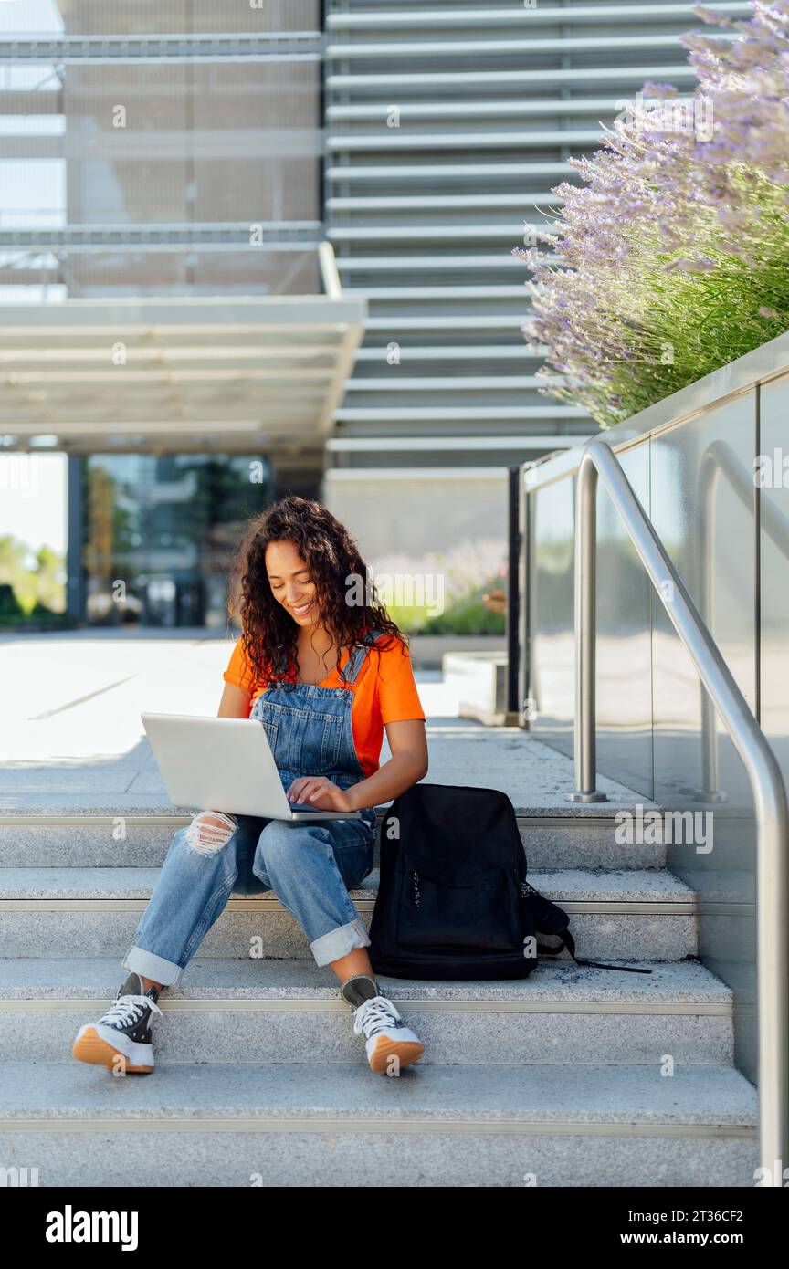 Happy student sitting on steps hi-res stock photography and images - Alamy