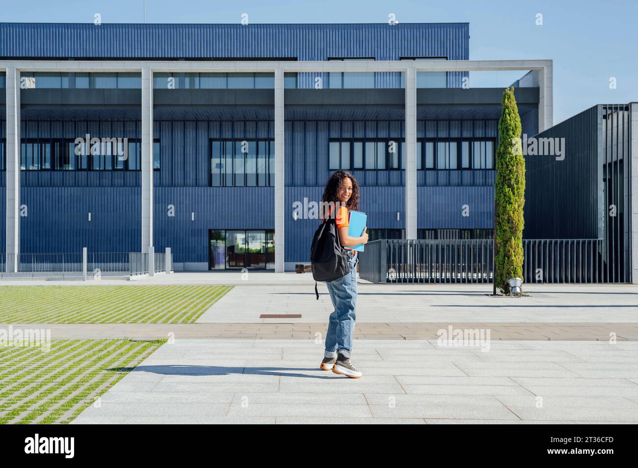 Smiling student with backpack standing in front of building Stock Photo ...