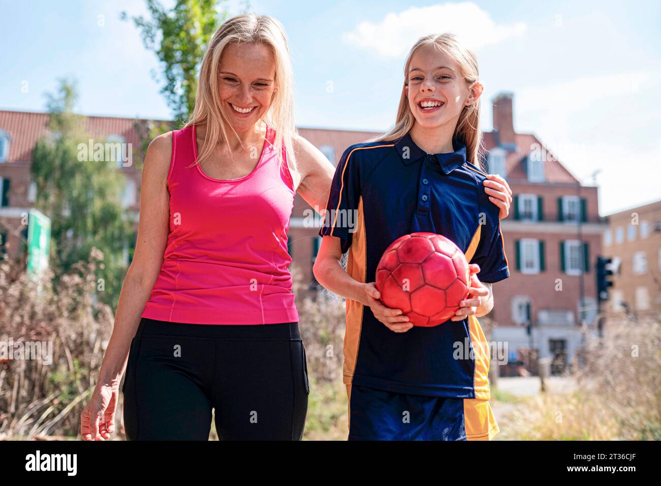 Mother and daughter with soccer ball in park Stock Photo - Alamy