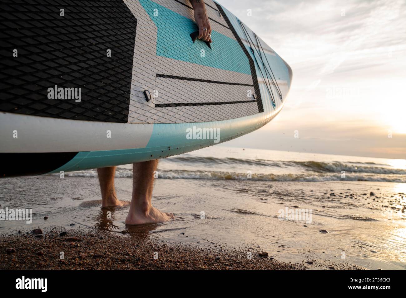 Man carrying paddleboard into sea hi-res stock photography and images ...