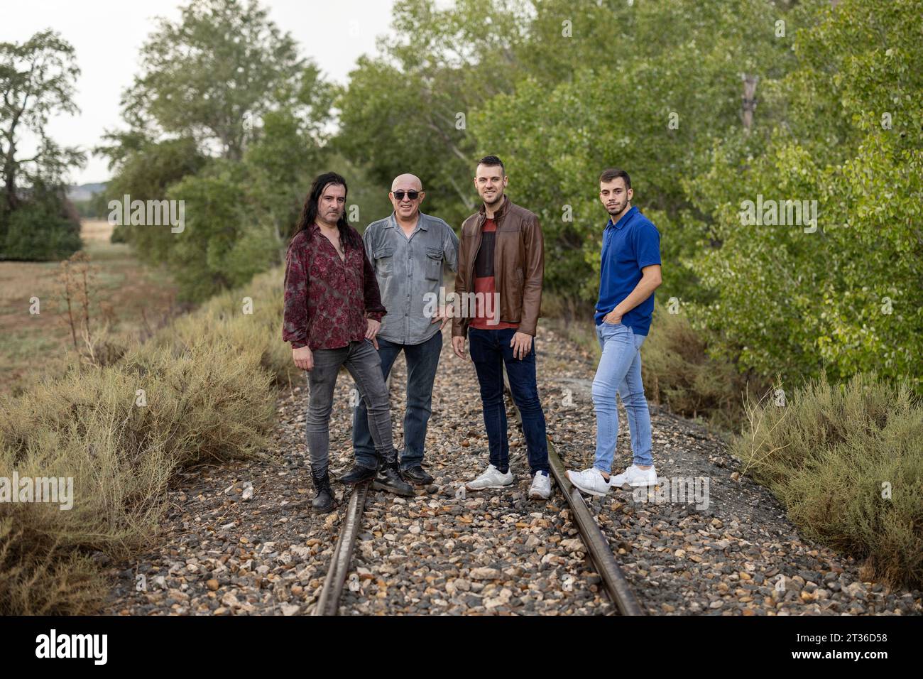Friends standing on railroad tracks amidst plants Stock Photo - Alamy