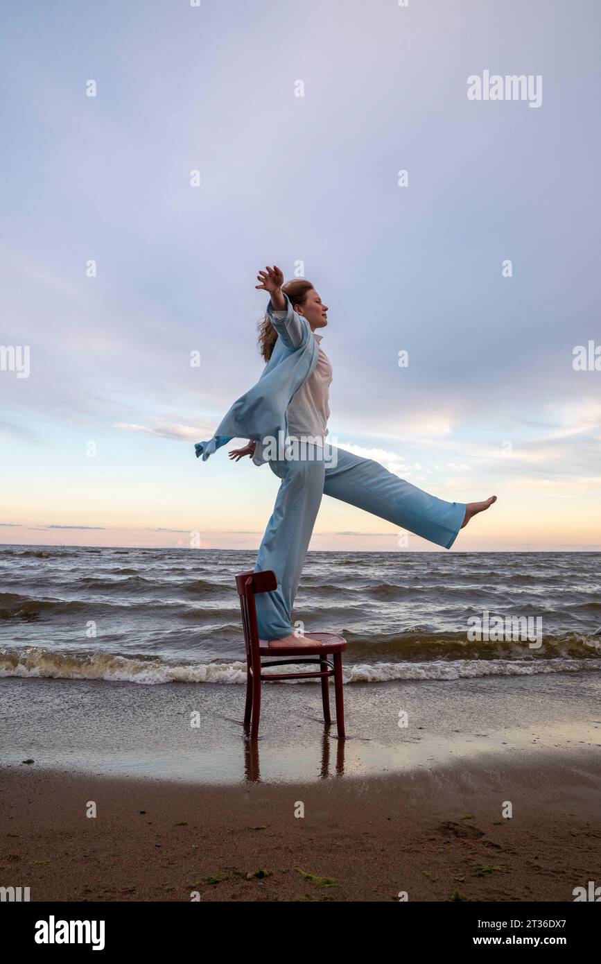 Woman standing leg on chair hi-res stock photography and images - Alamy