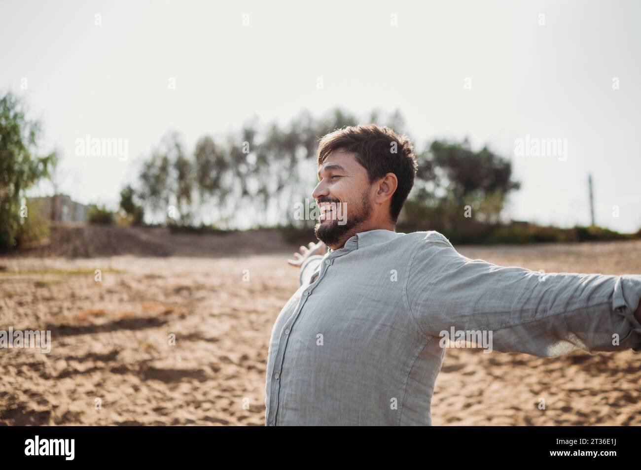 Happy man standing with arms outstretched at beach Stock Photo - Alamy