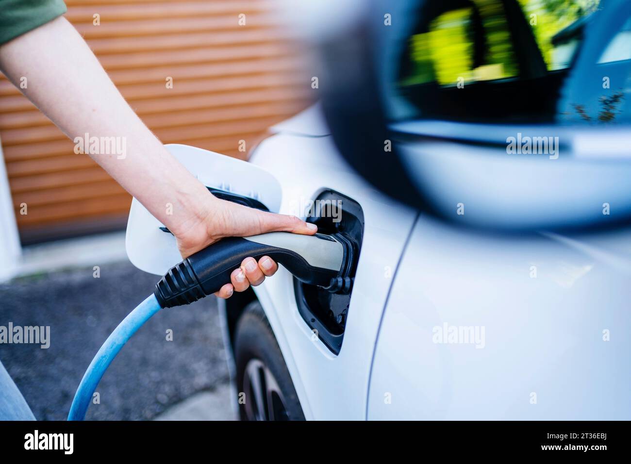 Hand of woman charging electric car Stock Photo - Alamy