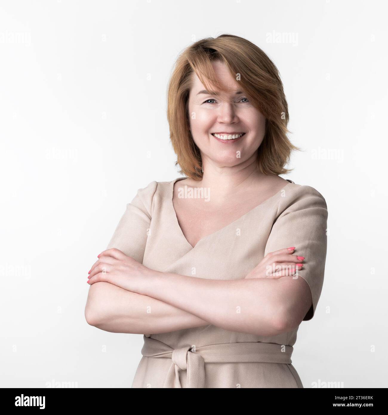 Mature Caucasian woman in casual dress looking at camera, standing on ...