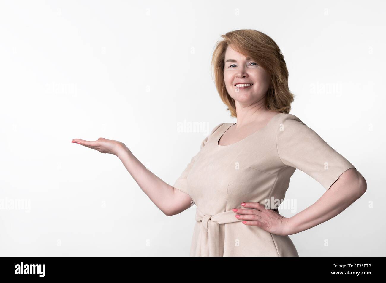 Adult woman wearing beige dress looking at camera. Female poses ...