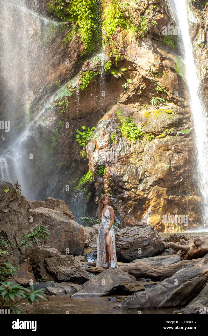 Woman in dress by tropical waterfall Stock Photo - Alamy