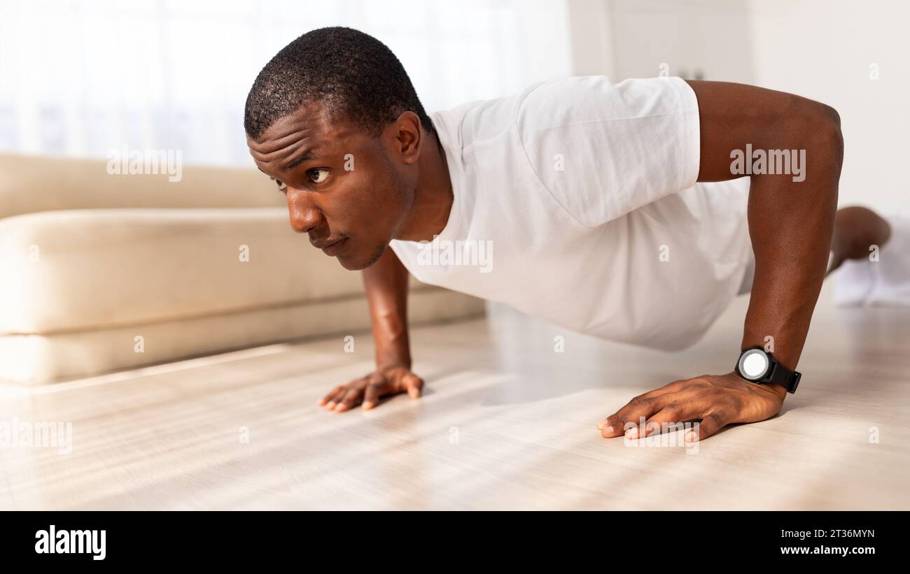 Black man exercising in his house gym, doing push ups Stock Photo - Alamy