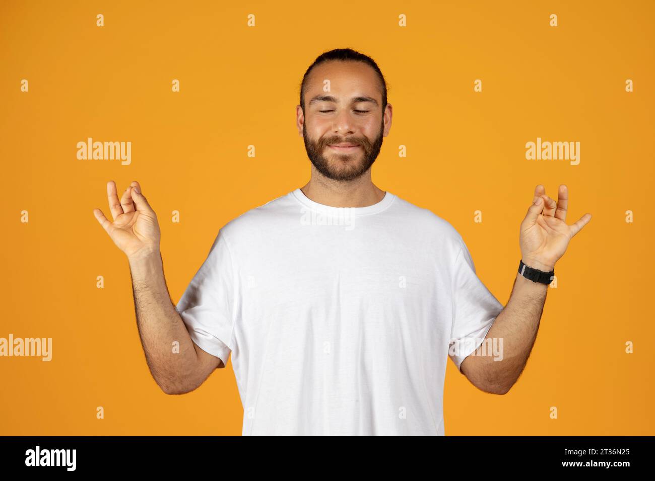 Smiling calm young caucasian guy with beard in white t-shirt rest ...