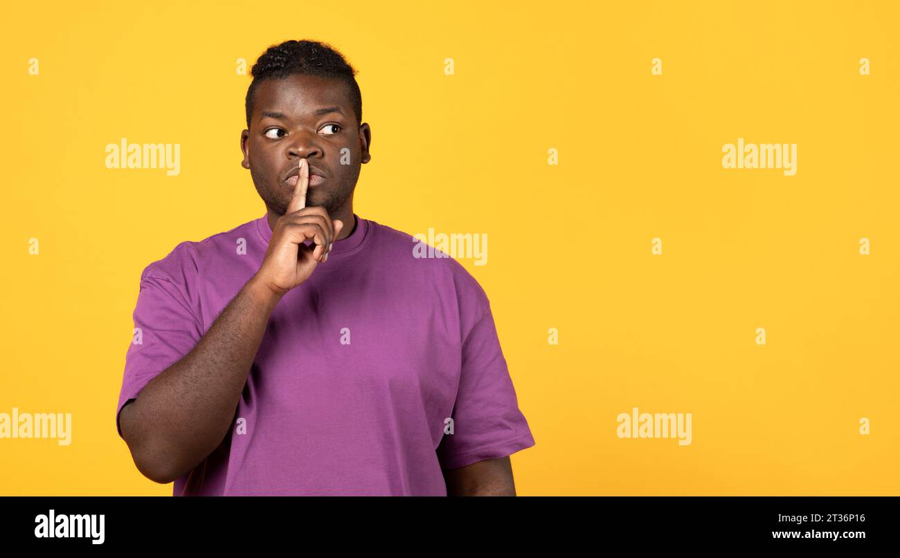 Black Young Man Gesturing Hush Sign Over Yellow Studio Background Stock ...