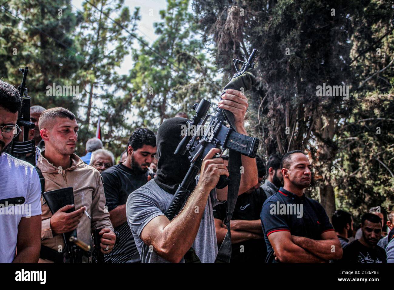A masked gunman takes part in the funeral of two Palestinian men, 29 ...