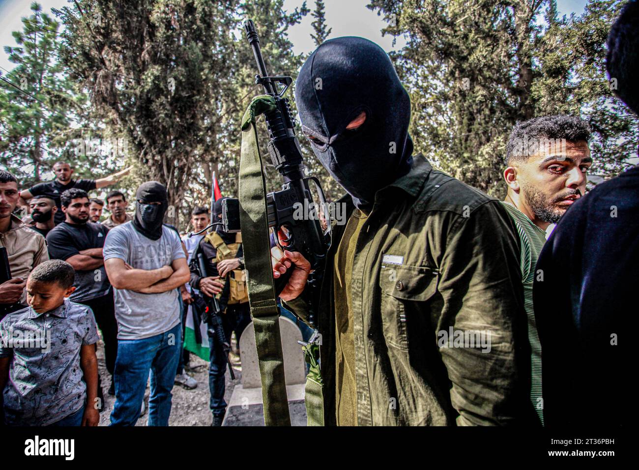 A masked gunman takes part in the funeral of two Palestinian men, 29 ...