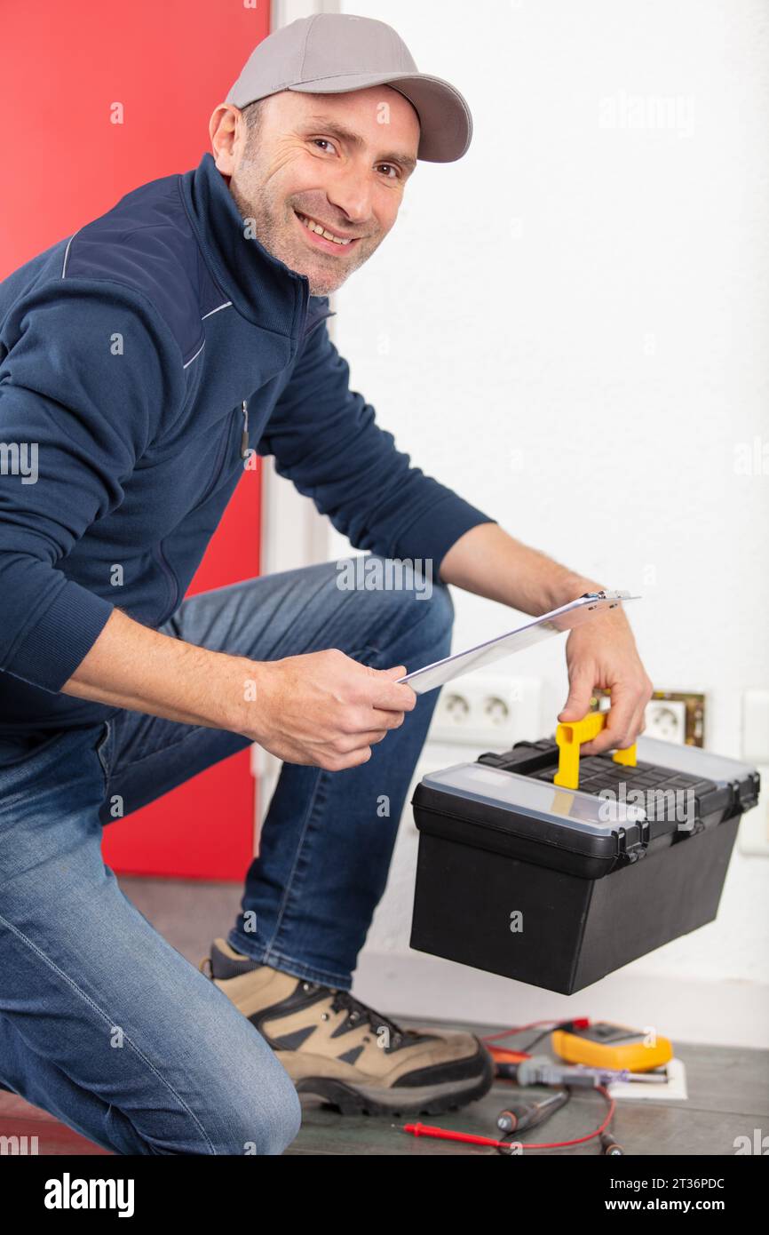 handyman sitting and holding toolbox Stock Photo - Alamy