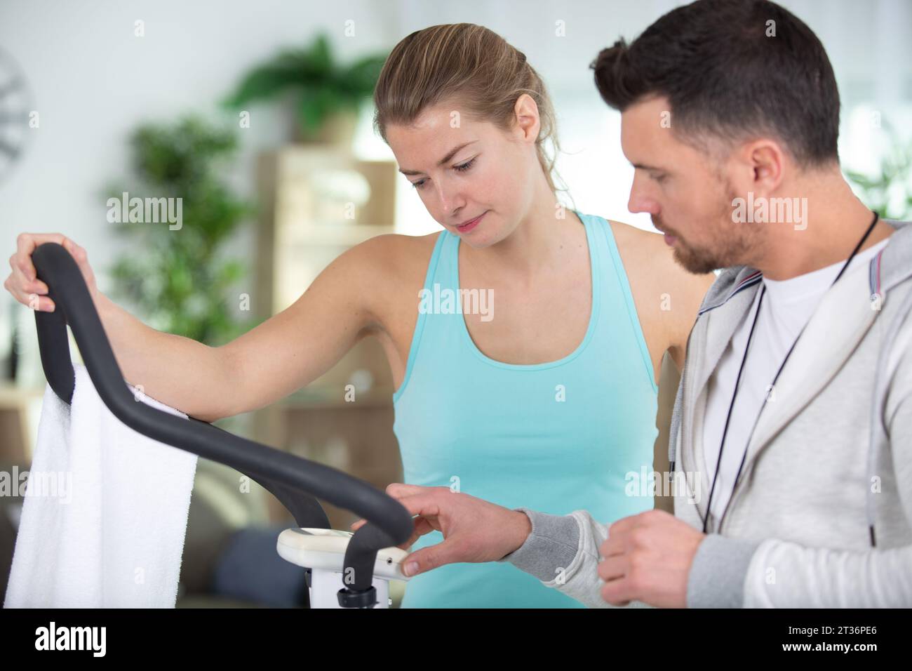 personal trainer explaining how to use a fitness machine Stock Photo ...