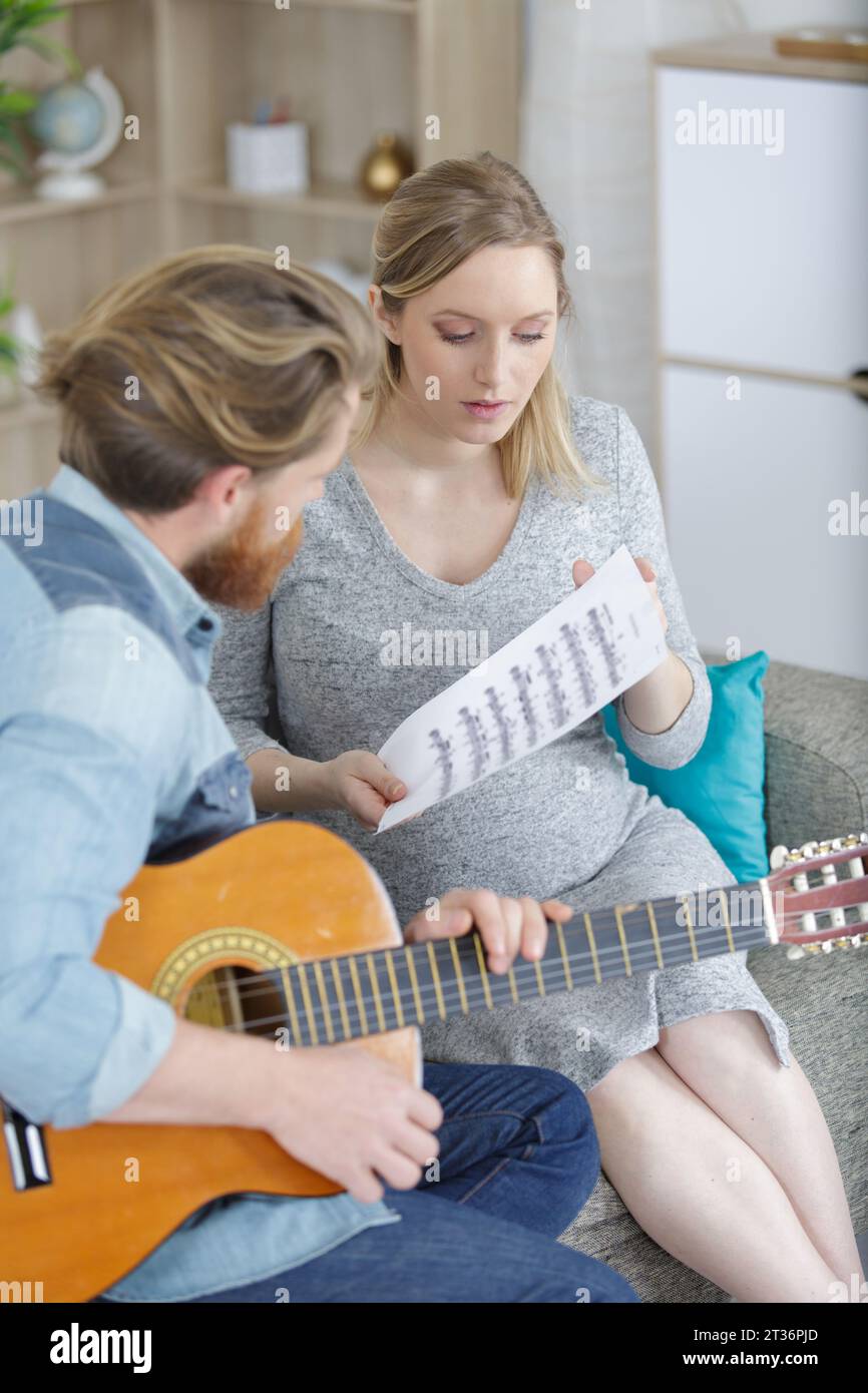 romantic couple enjoying at homeman playing guitar Stock Photo - Alamy