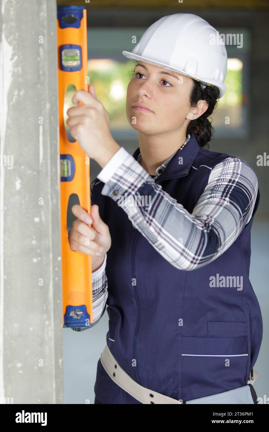 positive woman worker holding builders level Stock Photo - Alamy