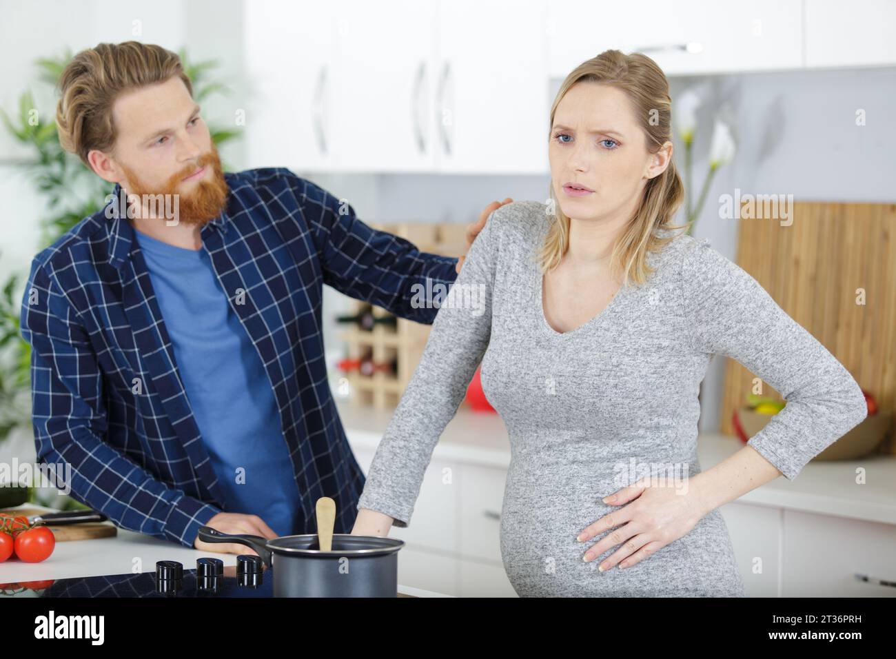 pregnant woman at home experiencing some abdomen pains Stock Photo - Alamy