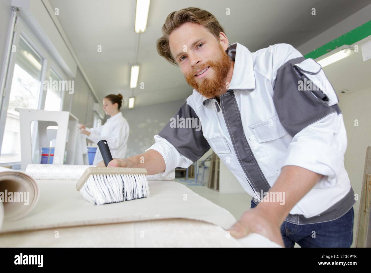 happy male smearing wallpaper with glue Stock Photo - Alamy