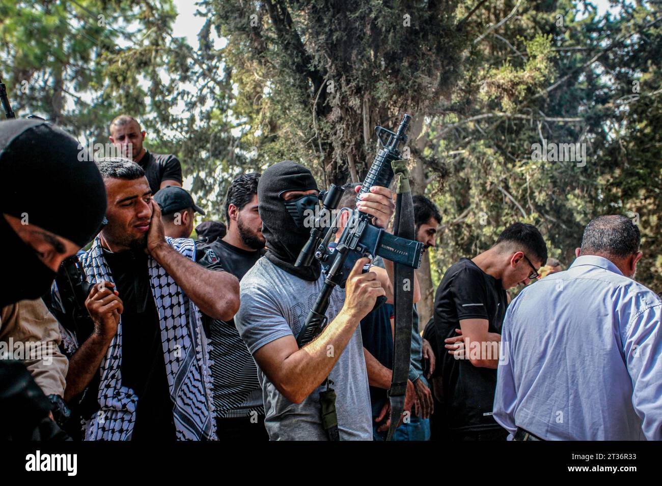 A masked gunman takes part in the funeral of two Palestinian men, 29 ...