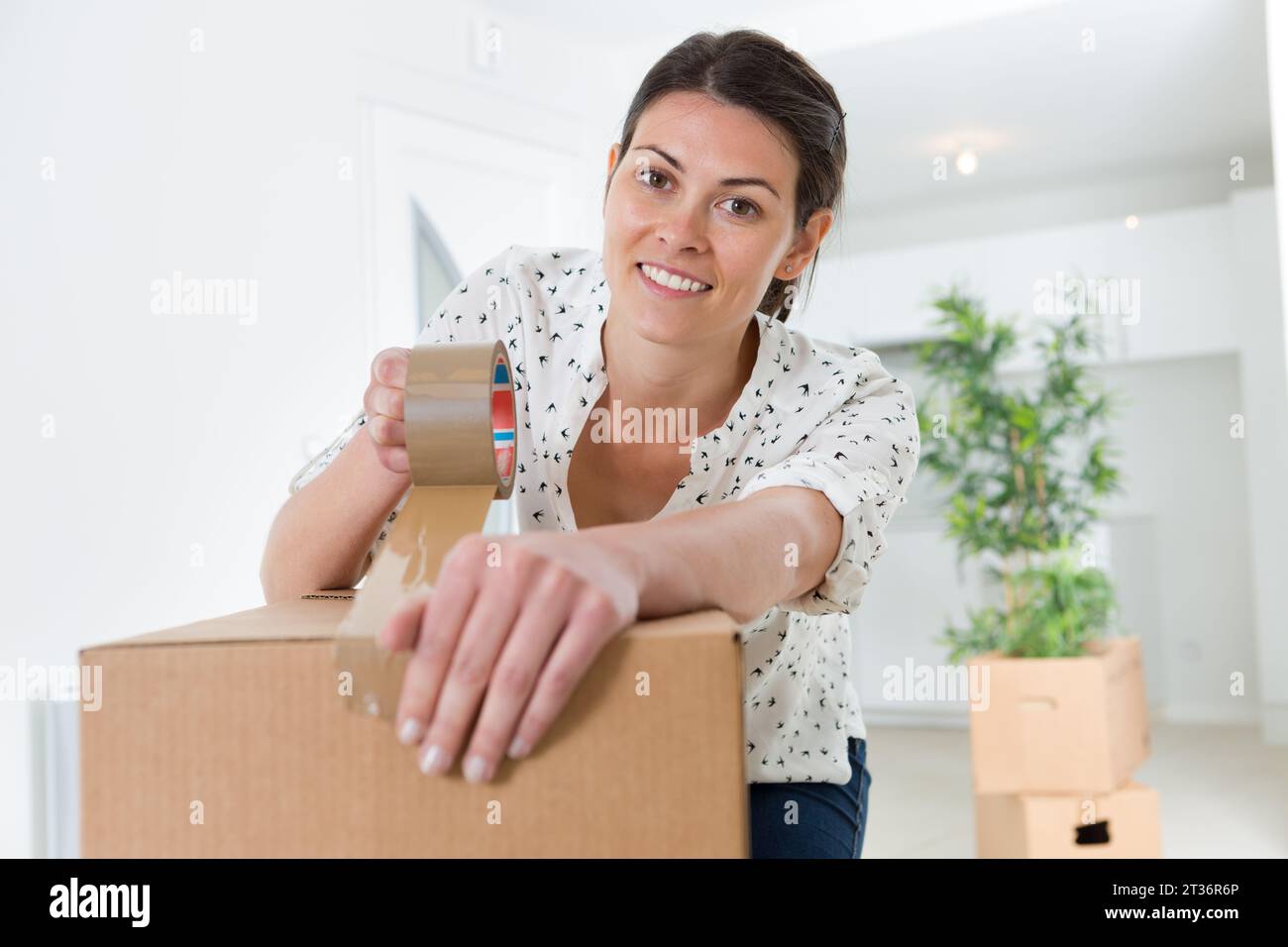 woman sealing the box with a tape Stock Photo - Alamy