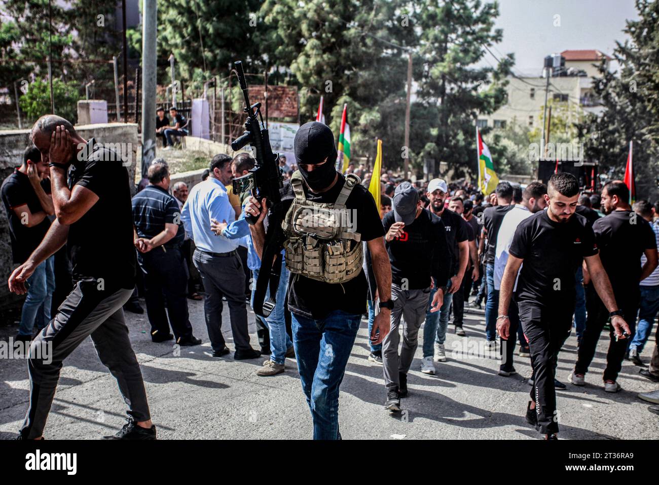 A masked gunman takes part in the funeral of two Palestinian men, 29 ...