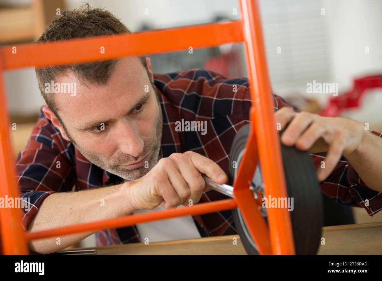 male worker fixing a trolley wheel Stock Photo - Alamy