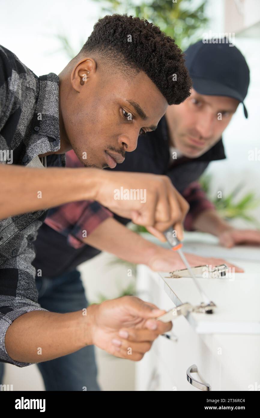 men working on a cupboard installation Stock Photo - Alamy