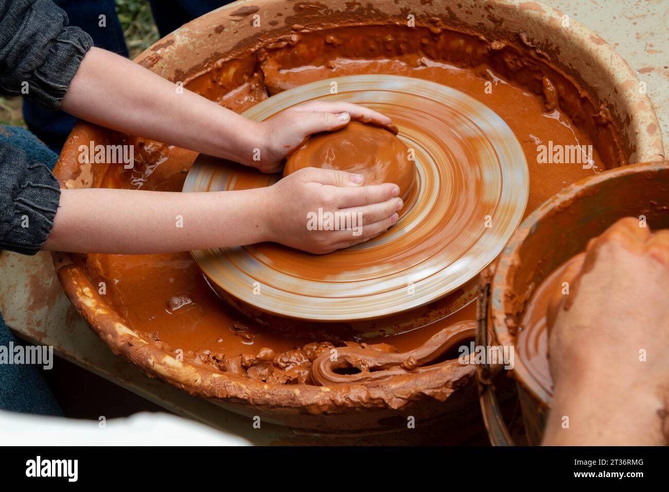 Pottery training. Rotating a clay pot on a machine. Hands knead clay ...