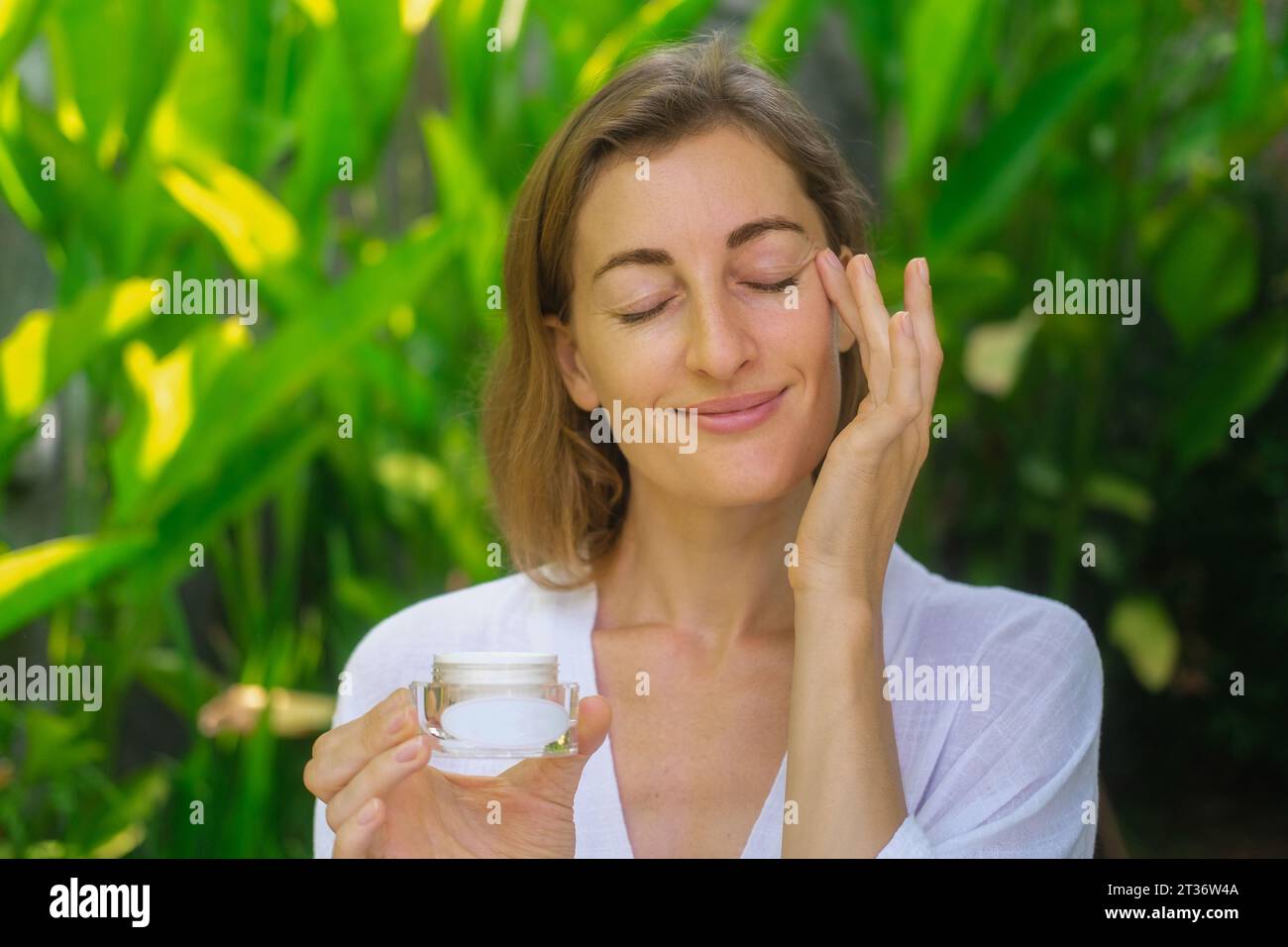 Close up of the face of a beautiful middle-aged woman. A woman applies ...