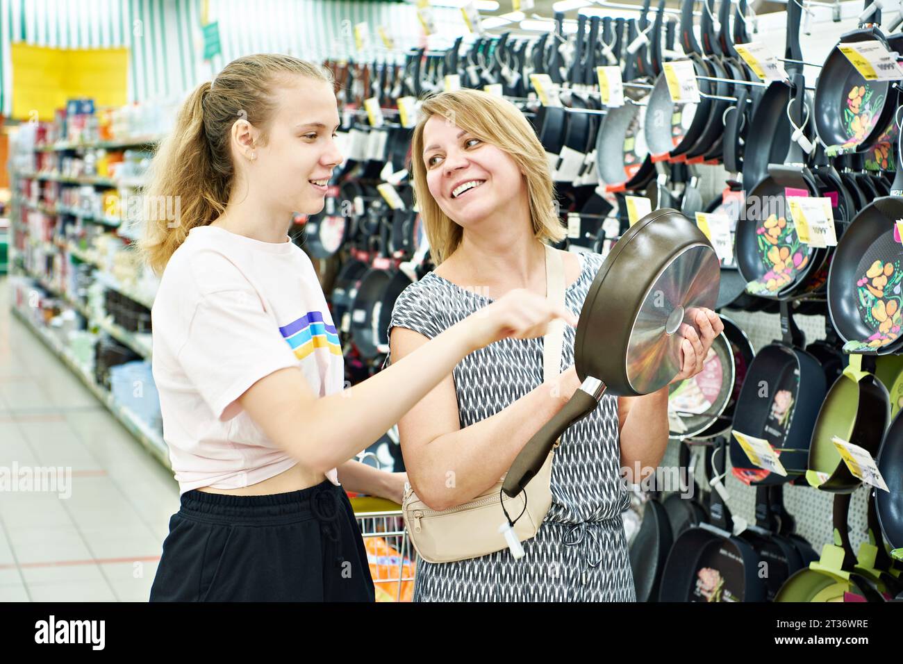 Mother and daughter choose a frying pan in a supermarket Stock Photo ...
