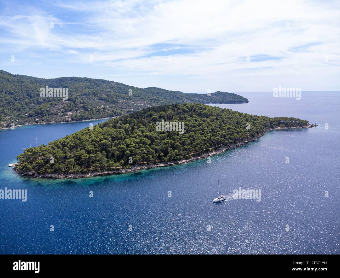 Small green island in blue sea and sailboat panoramic drone image Stock ...