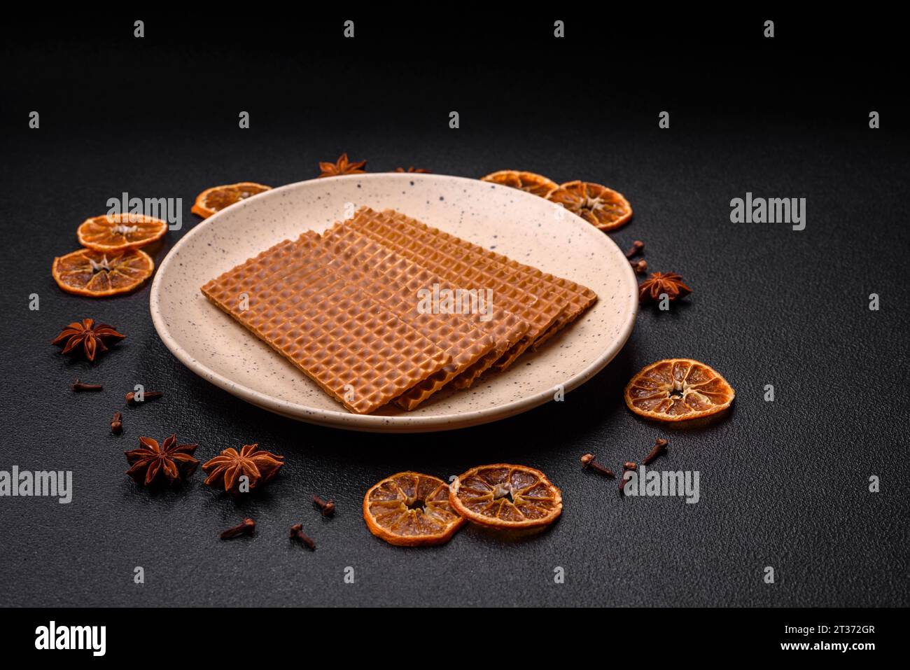 Delicious sweet crispy rectangular waffles on a ceramic plate on a dark ...