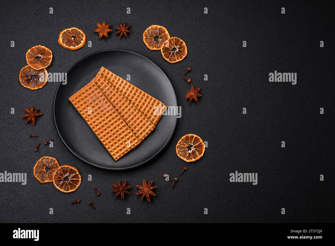 Delicious sweet crispy rectangular waffles on a ceramic plate on a dark ...