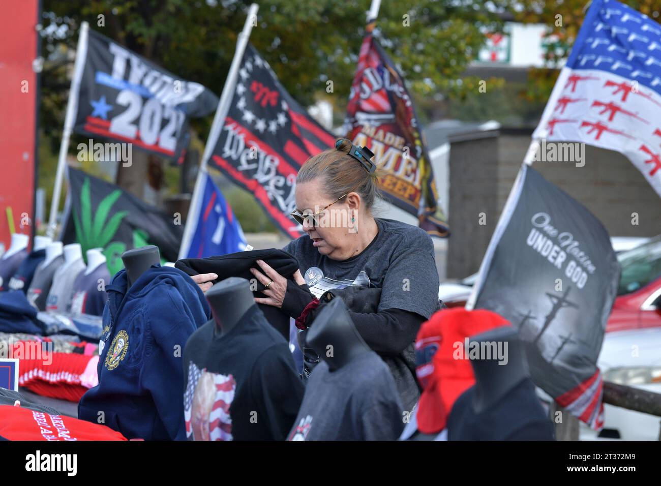 Derry, USA. 23rd Oct, 2023. A vendor folds shirts on their merchandise ...