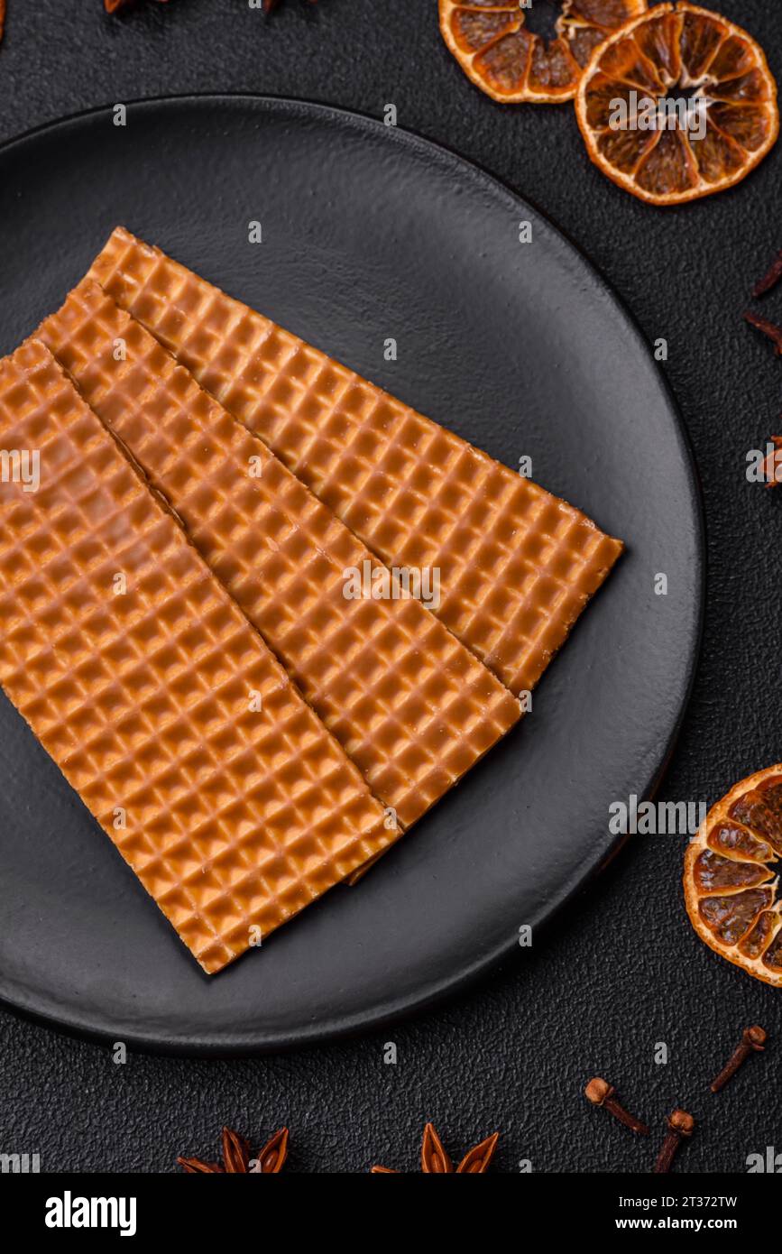 Delicious sweet crispy rectangular waffles on a ceramic plate on a dark ...