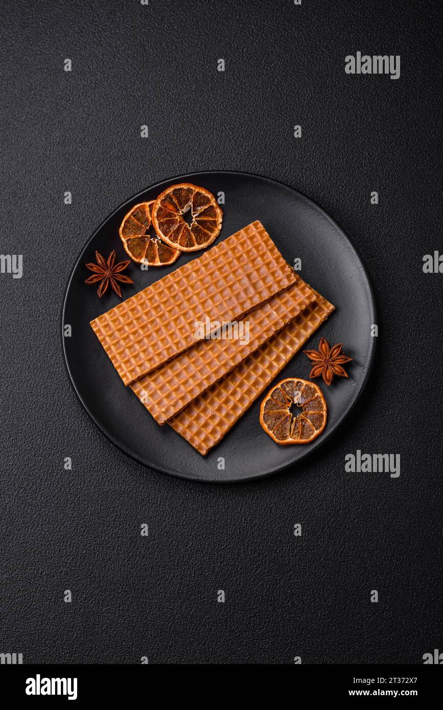 Delicious sweet crispy rectangular waffles on a ceramic plate on a dark ...