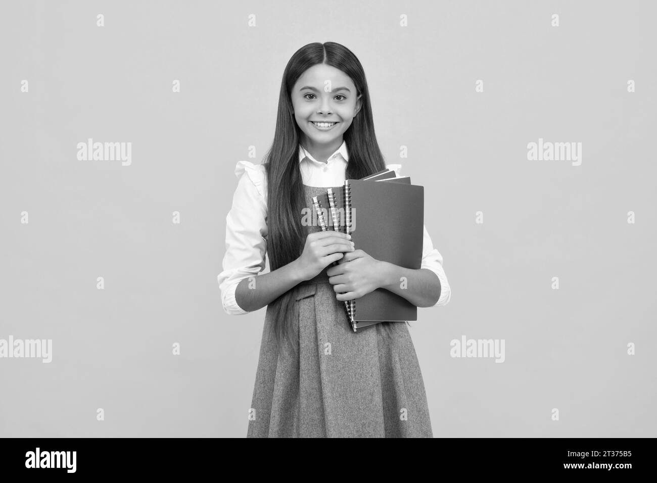 Teen girl pupil hold books, notebooks, isolated on yellow background ...